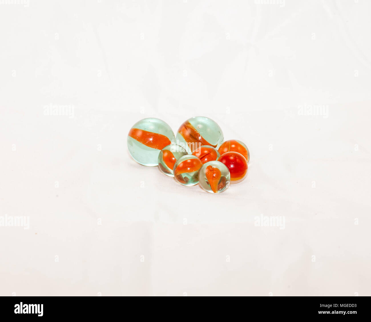 two sizes of orange cats-eye marbles at rest Stock Photo - Alamy