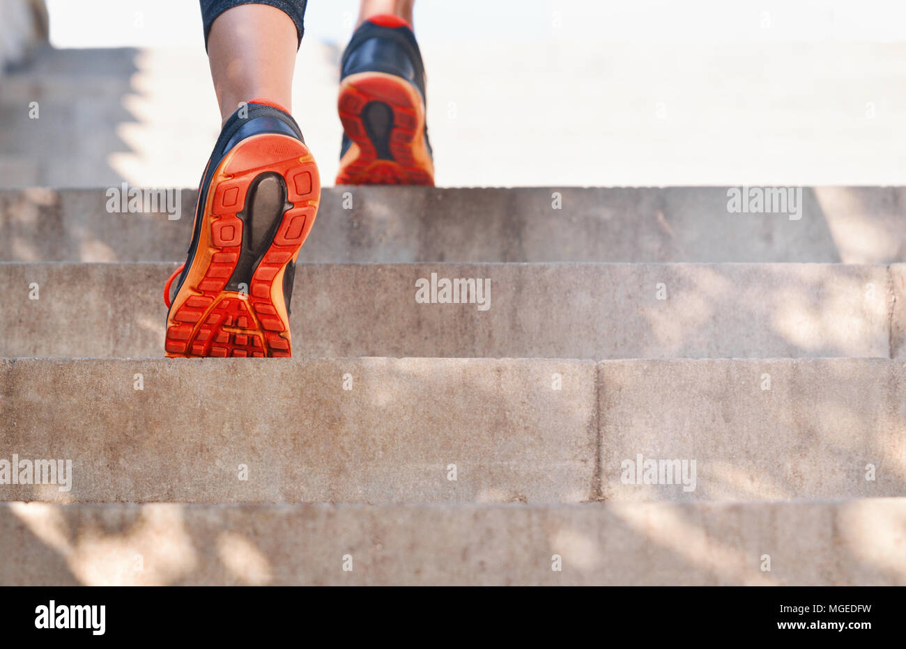 Low angle rear portrait of female runner in action on staircase Stock ...
