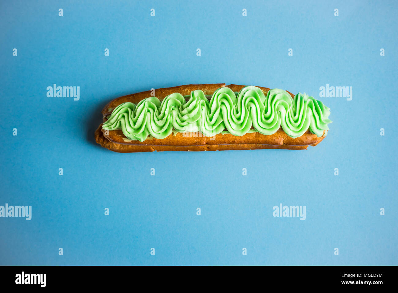 Eclair sweet on blue background as a dessert concept with copy space ...