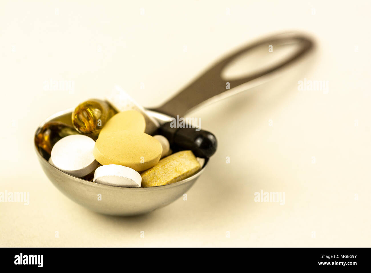 Multiple vitamins and nutrients in a measuring spoon (tablespoon Stock ...