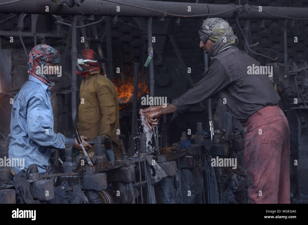 Lahore, Pakistan. 28th Apr, 2018. Pakistani laborers are busy melting ...