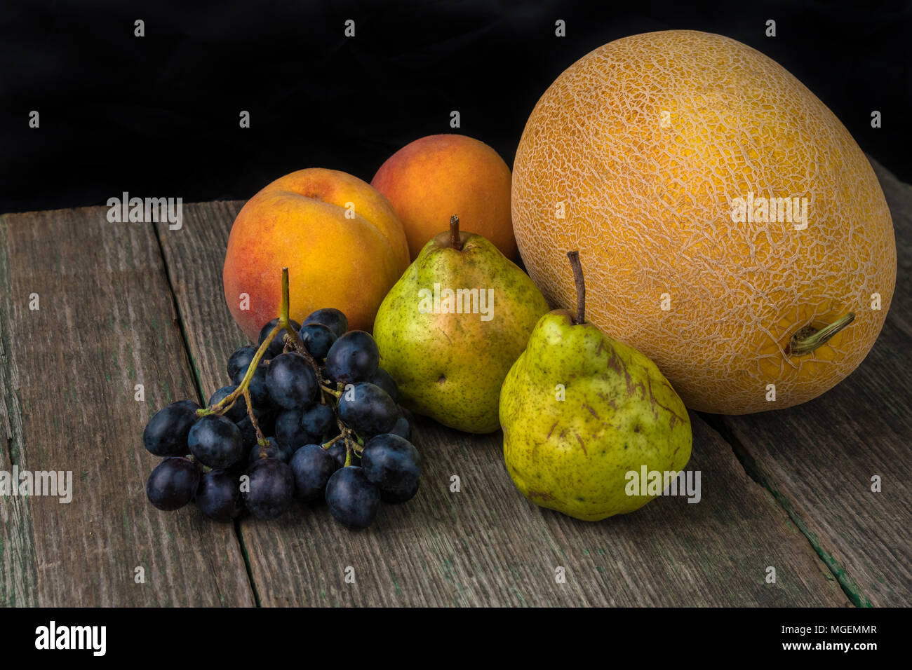 Melon, grapes, peach and Pear on old wooden table Stock Photo - Alamy