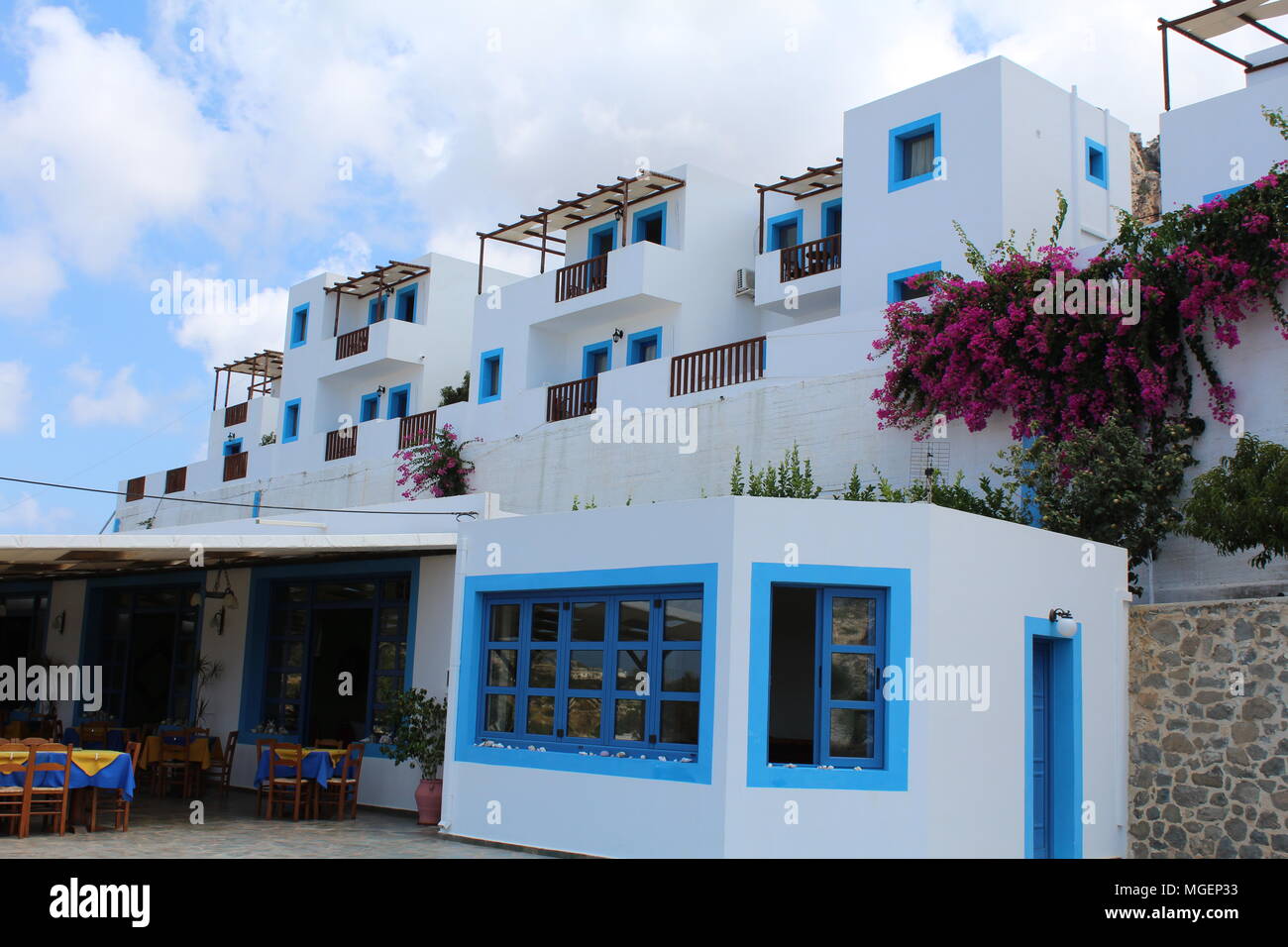 Typical white and blue Greek houses with purple flowers that descend ...