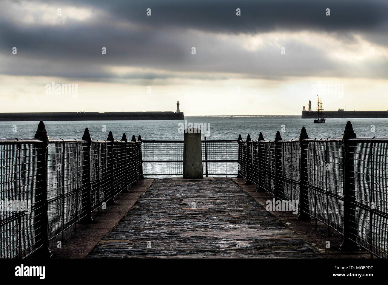 A slatted concrete pier overlooks the rough sea of Dover in England, on ...