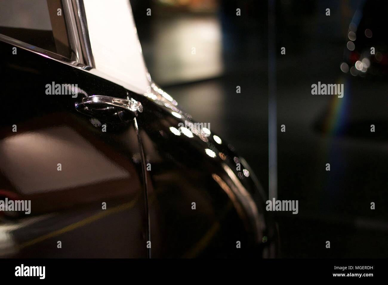 Polished handle of a car door of an old black convertible car, with a ...