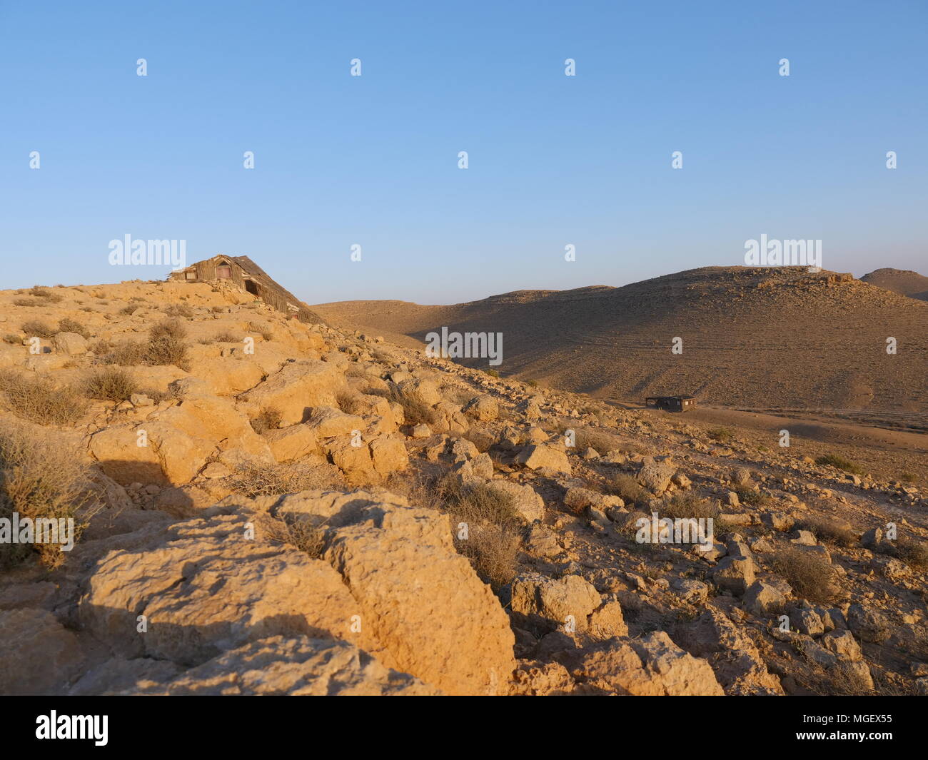Arid desert mountain landscape with rocks and a single distant small ...
