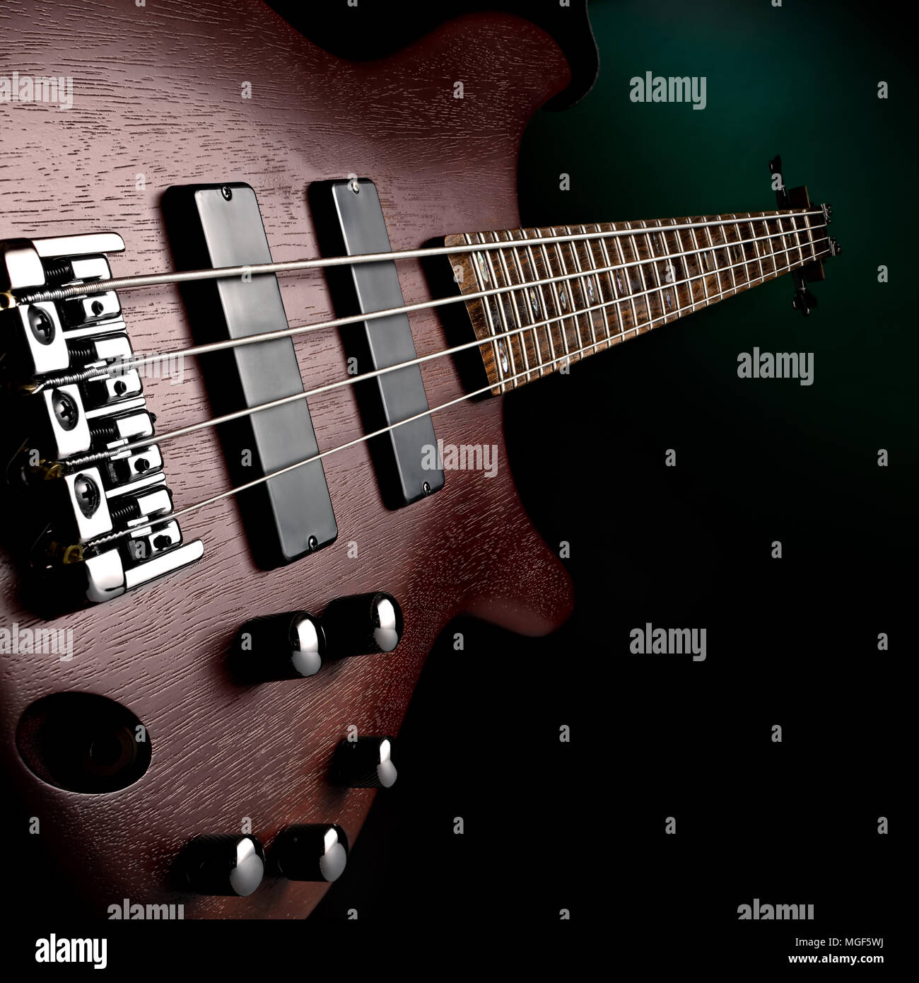 Maroon four string bass guitar. Close up shoot on green and black ...