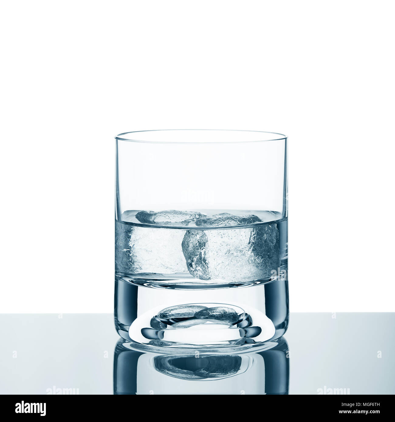 Glass of vodka with ice on a white background and reflective surface ...