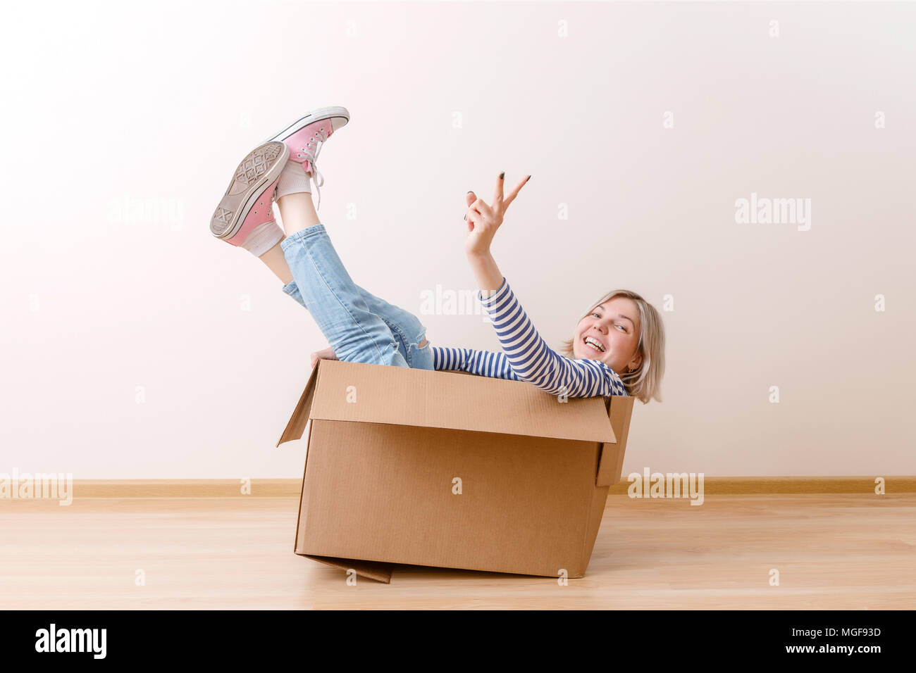 Photo of young woman sitting in cardboard box Stock Photo - Alamy