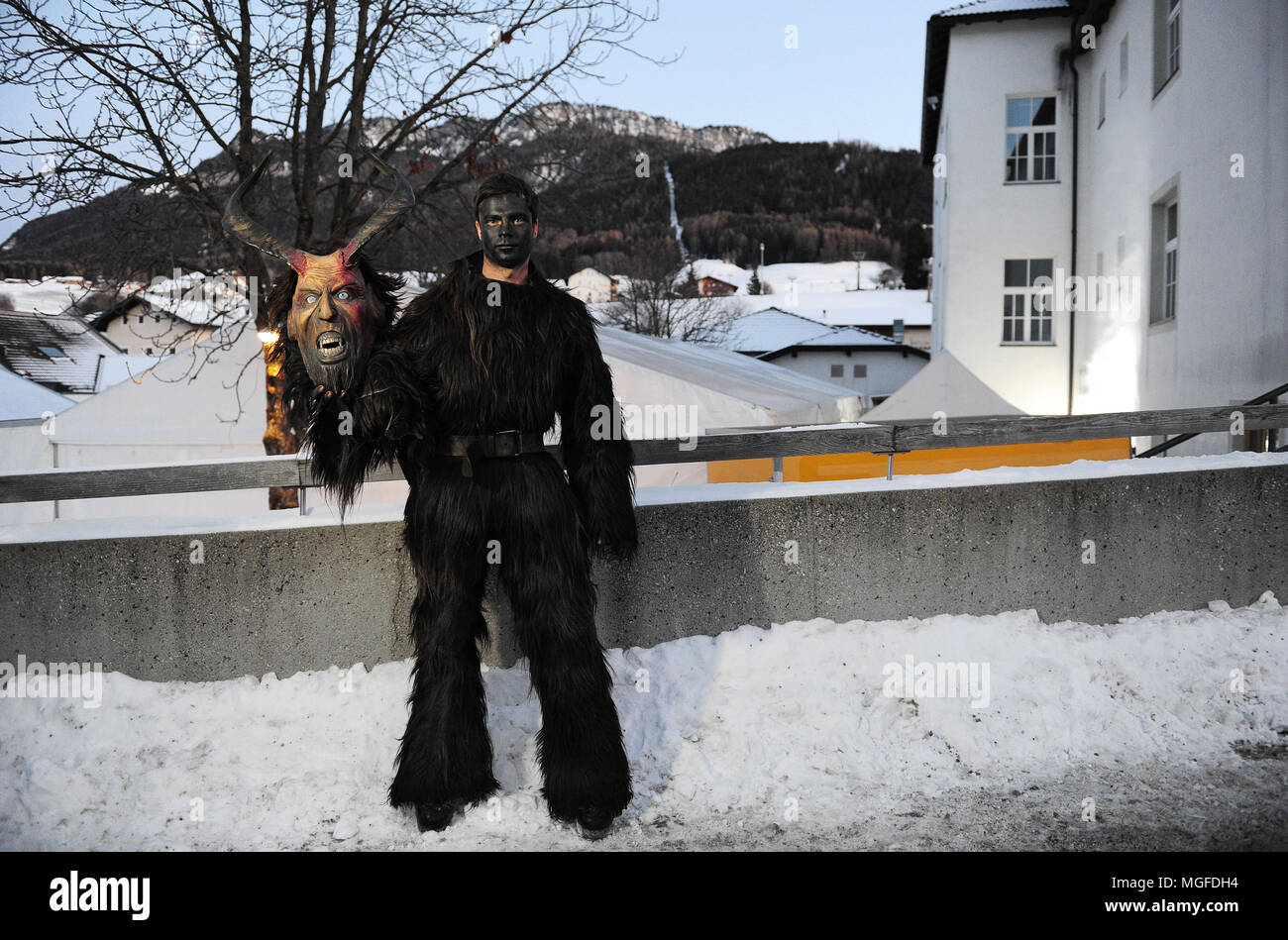 A man dressed as a Krampus poses for a picture holding his mask before ...