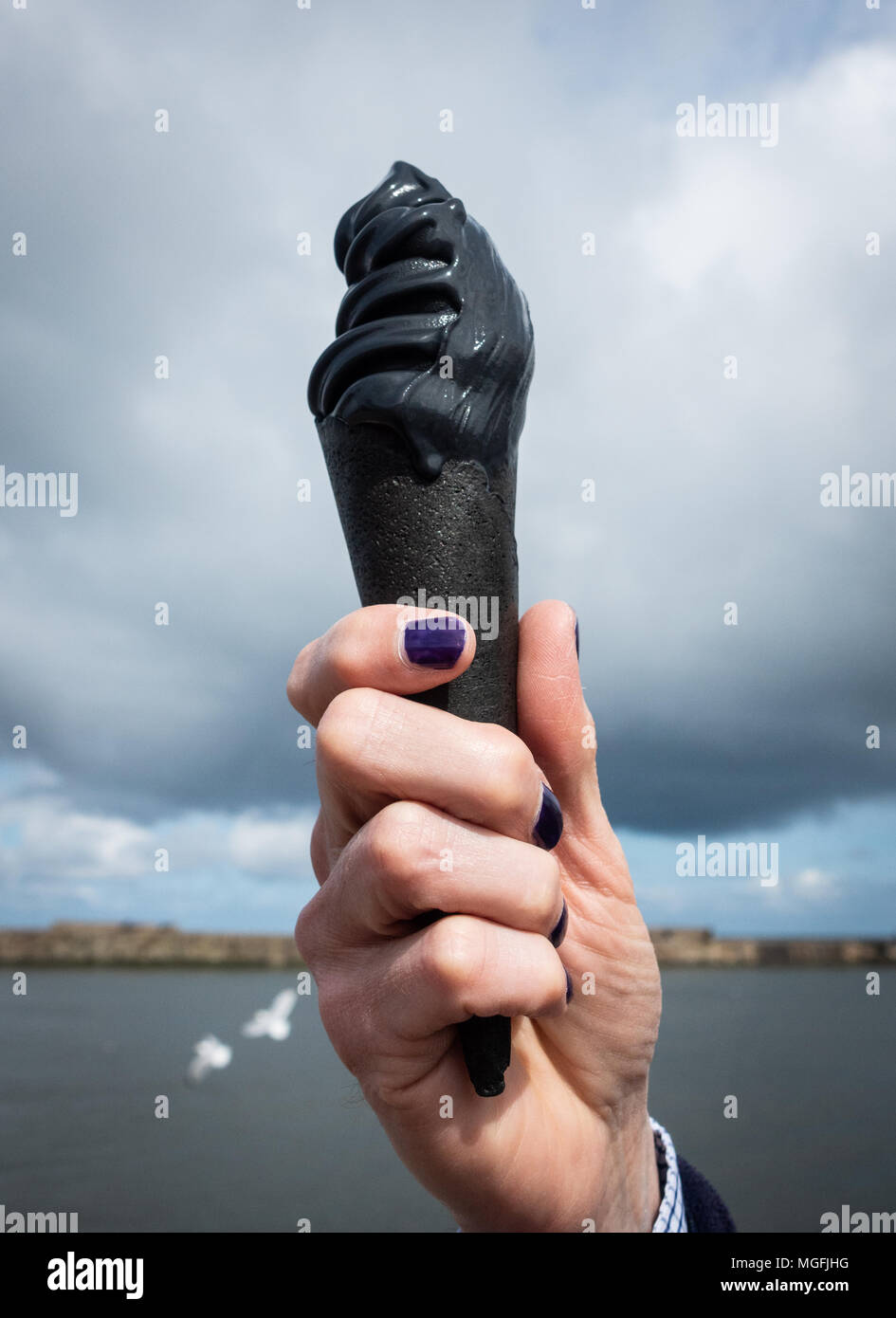 Woman holding "Whitby Jet" black ice cream at Whitby Goth weekend ...