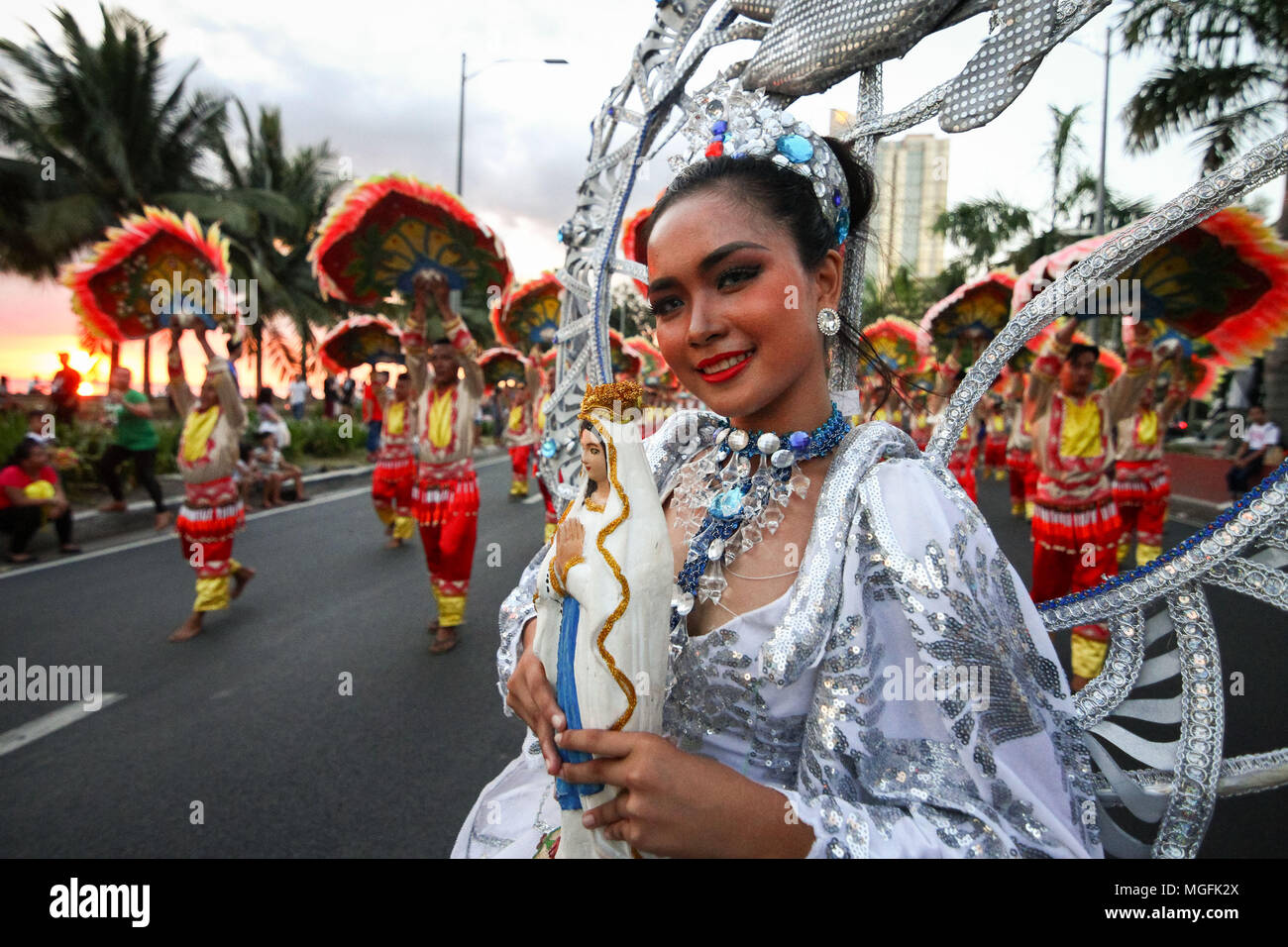 A young lady seen holding a statue of the Virgin Mary while dancing ...
