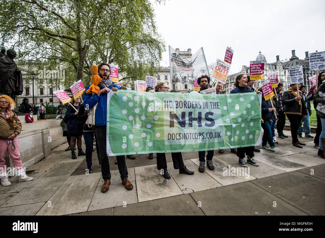London, UK. 28th Apr, 2018. Protesters seen carrying a large banner ...