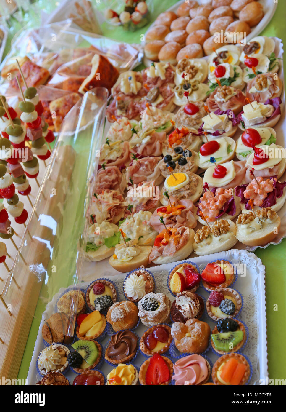 buffet with many trays overflowing with sweet pastries and sandwiches ...