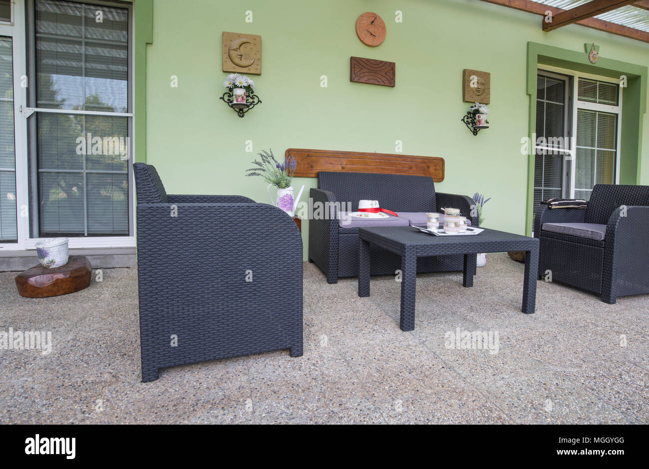 Plastic rattan patio furniture with rustic decoration Stock Photo - Alamy