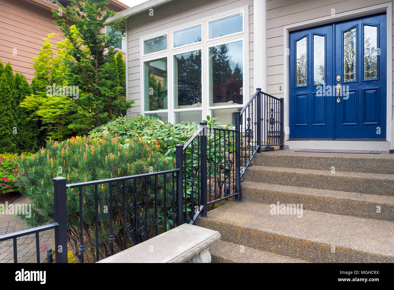 House with blue double doors concrete steps entry by landscaped front ...