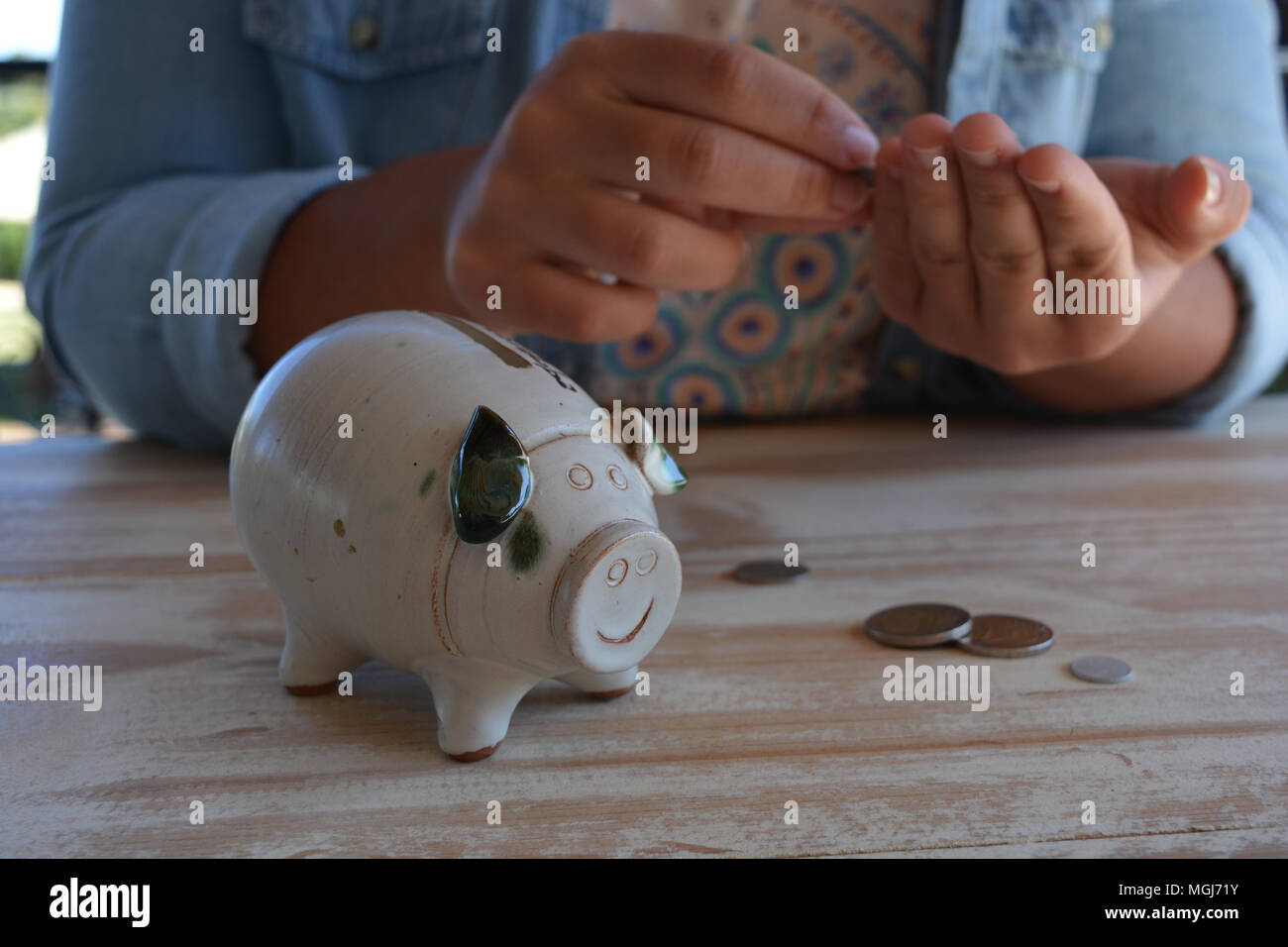 Millennial woman counting money from a piggy bank Stock Photo - Alamy