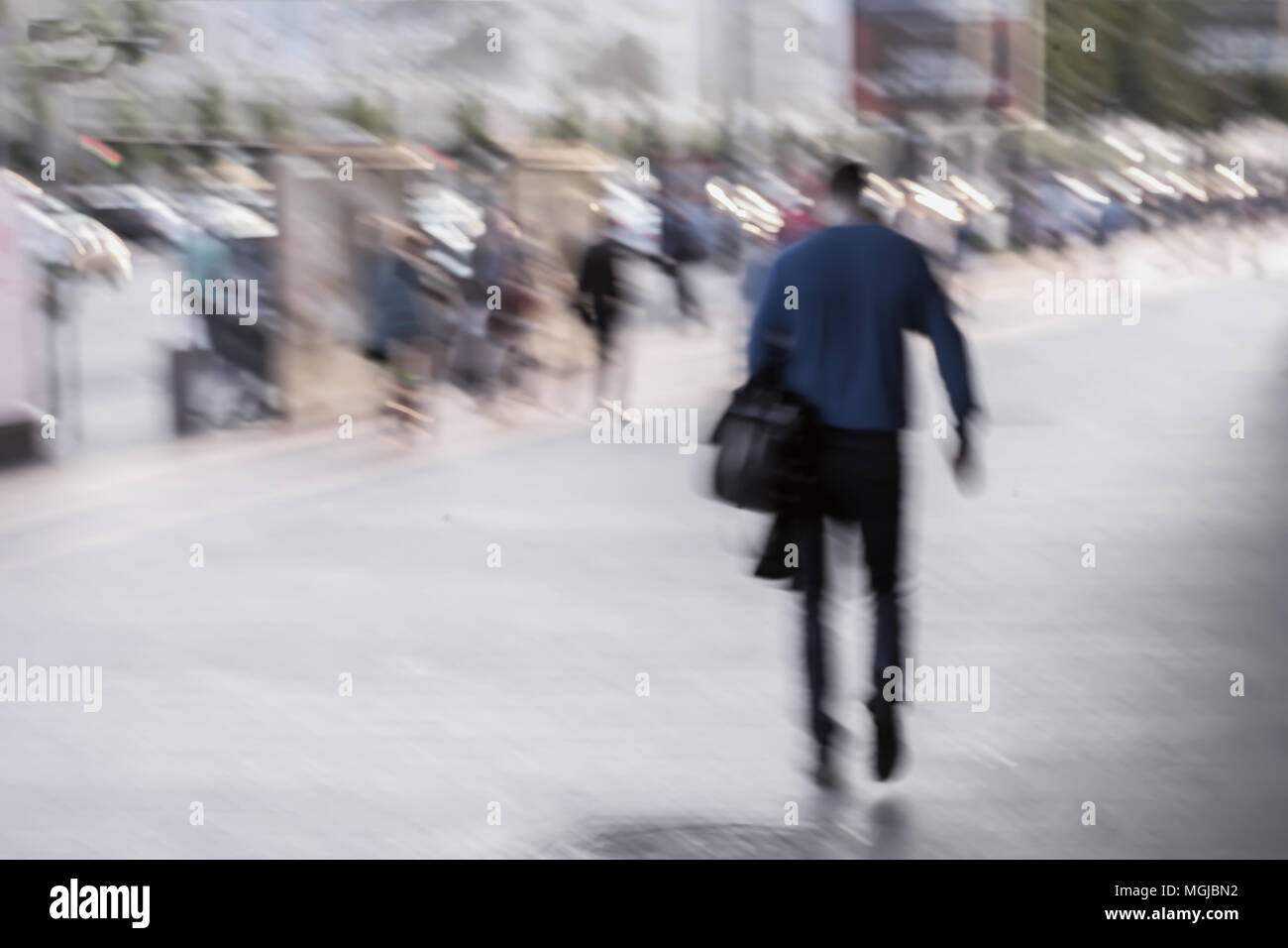 Abstract image of blurred man with portfolio in a hurry in the city ...