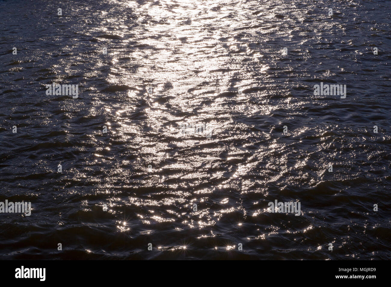 reflections of evening sun on rippled water in the river. background ...