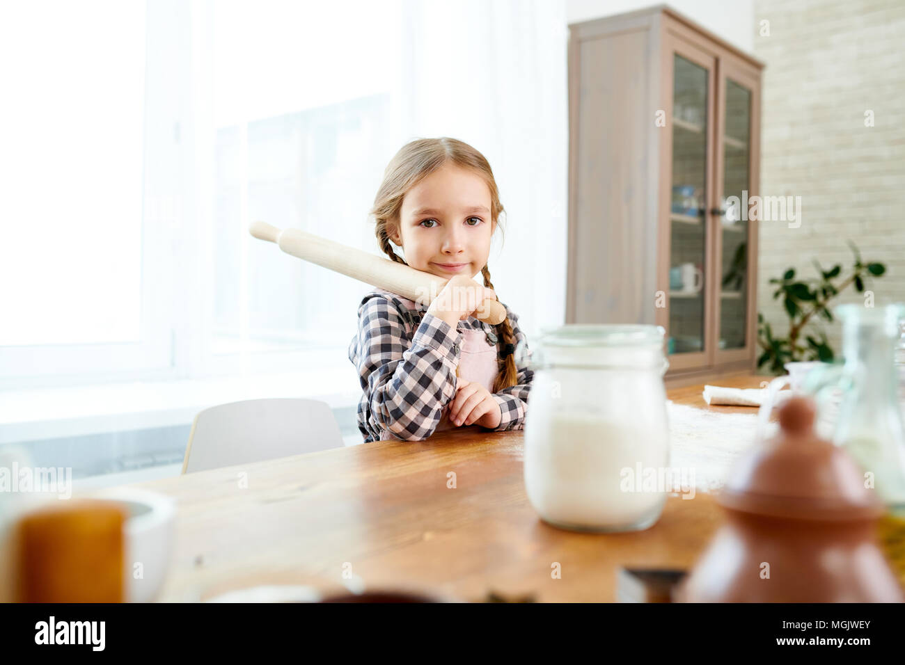 Cute little girl with rolling pin in hands posing for photography while ...