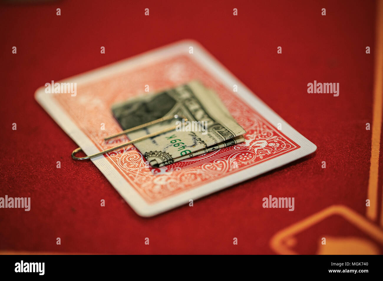 Playing card with a banknote Stock Photo - Alamy