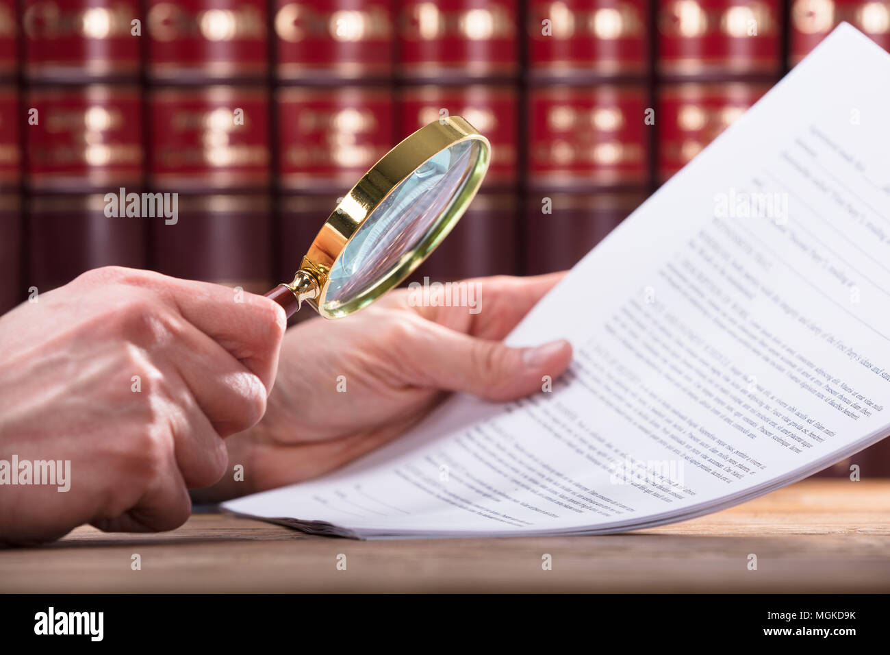 Human Hand Examining Document Through Magnifying Glass Stock Photo - Alamy