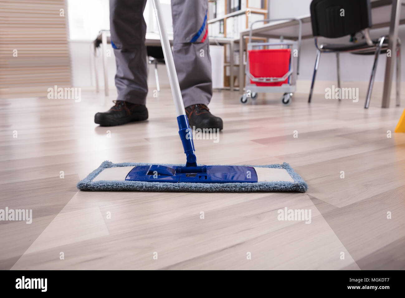 Cleaner Cleaning Hardwood Floor With Mop At Workplace Stock Photo - Alamy