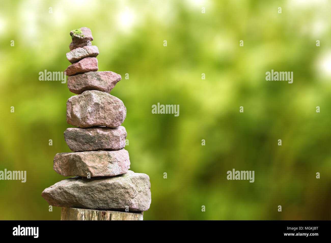 Stacked stone pyramid in front of green blurry background Stock Photo ...
