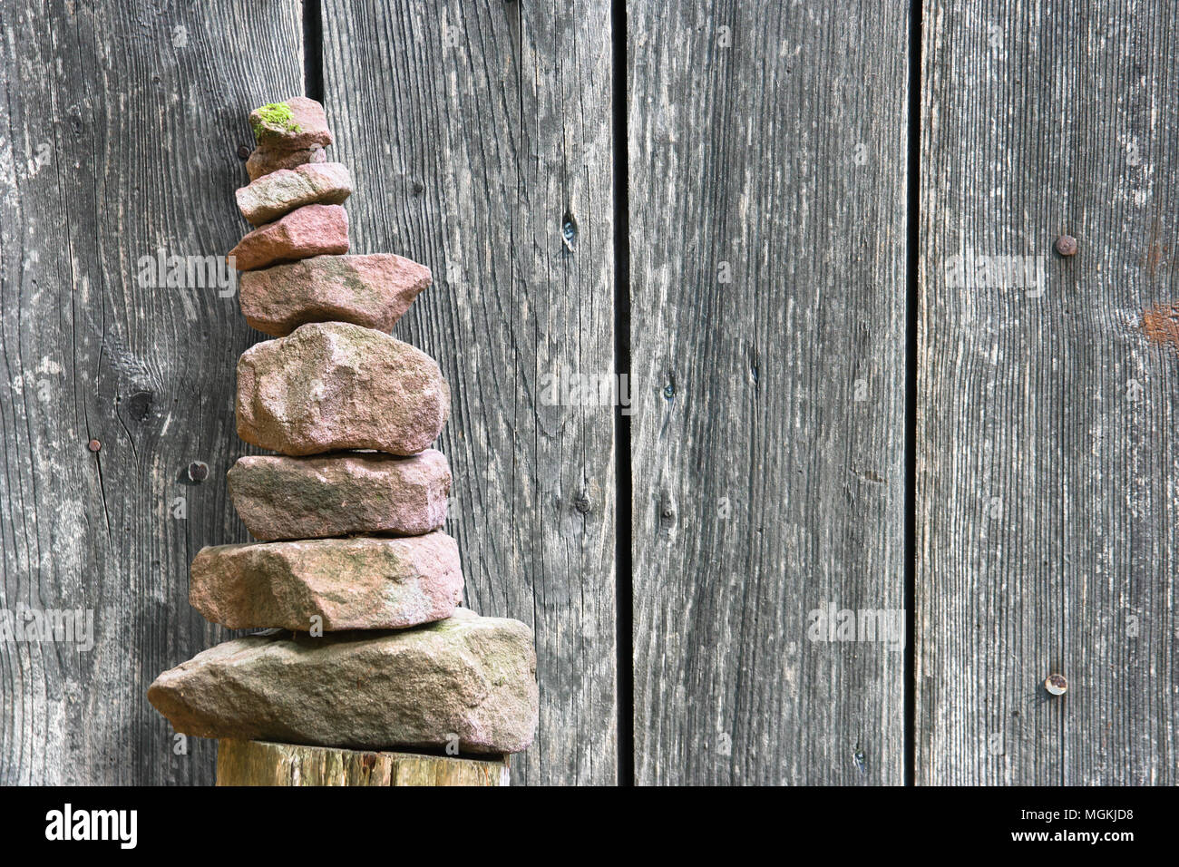 Stacked stone pyramid in front of a wooden wall Stock Photo - Alamy