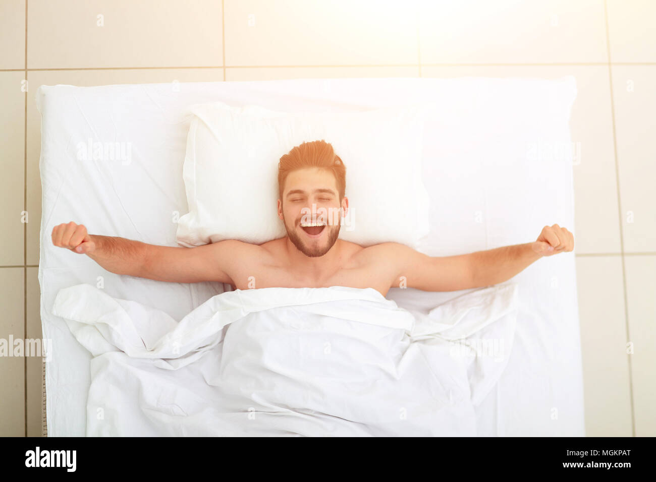 top view. happy man waking up in a comfortable bed Stock Photo - Alamy