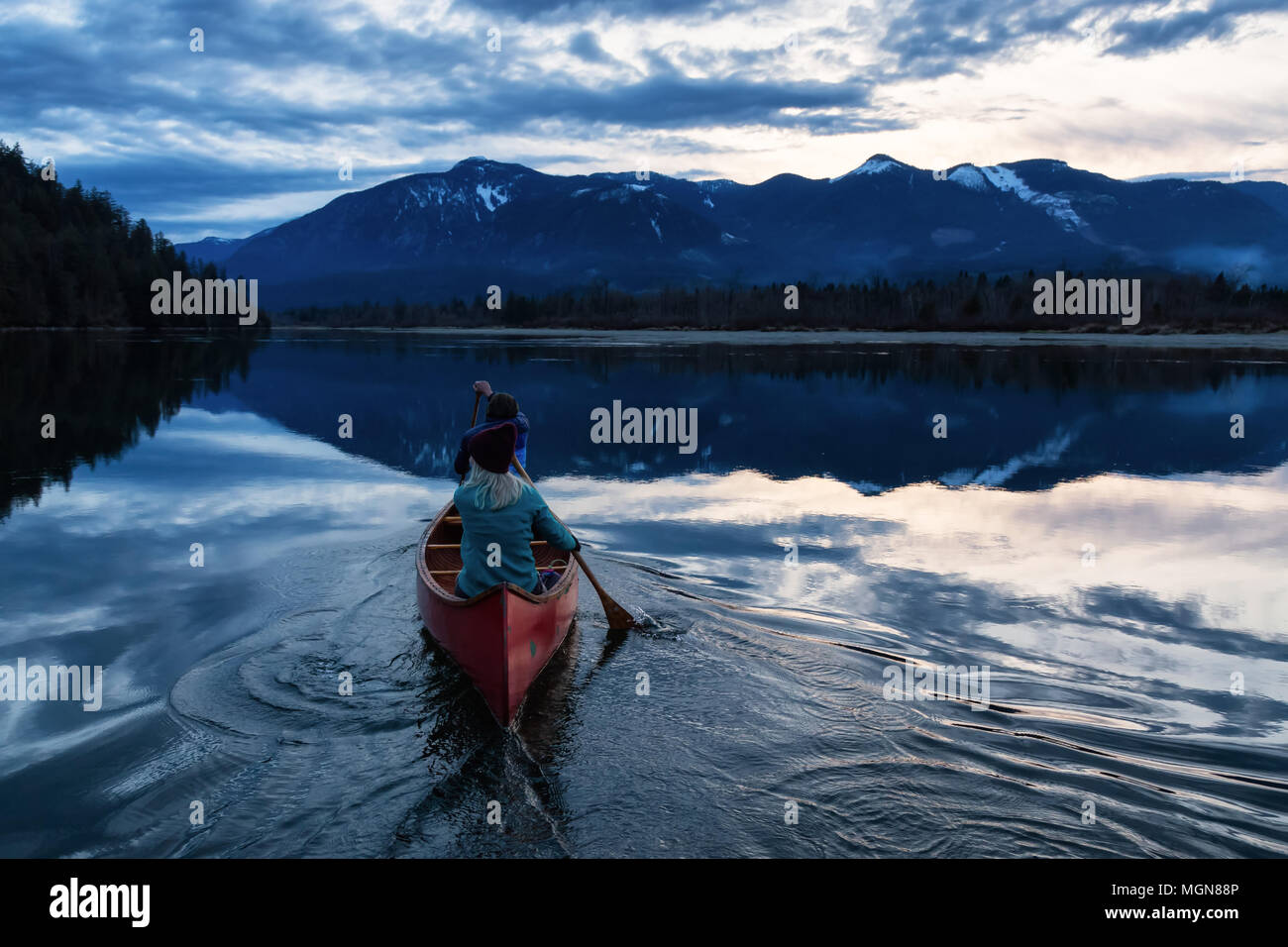 Adventurous people on a wooden canoe are enjoying the beautiful ...