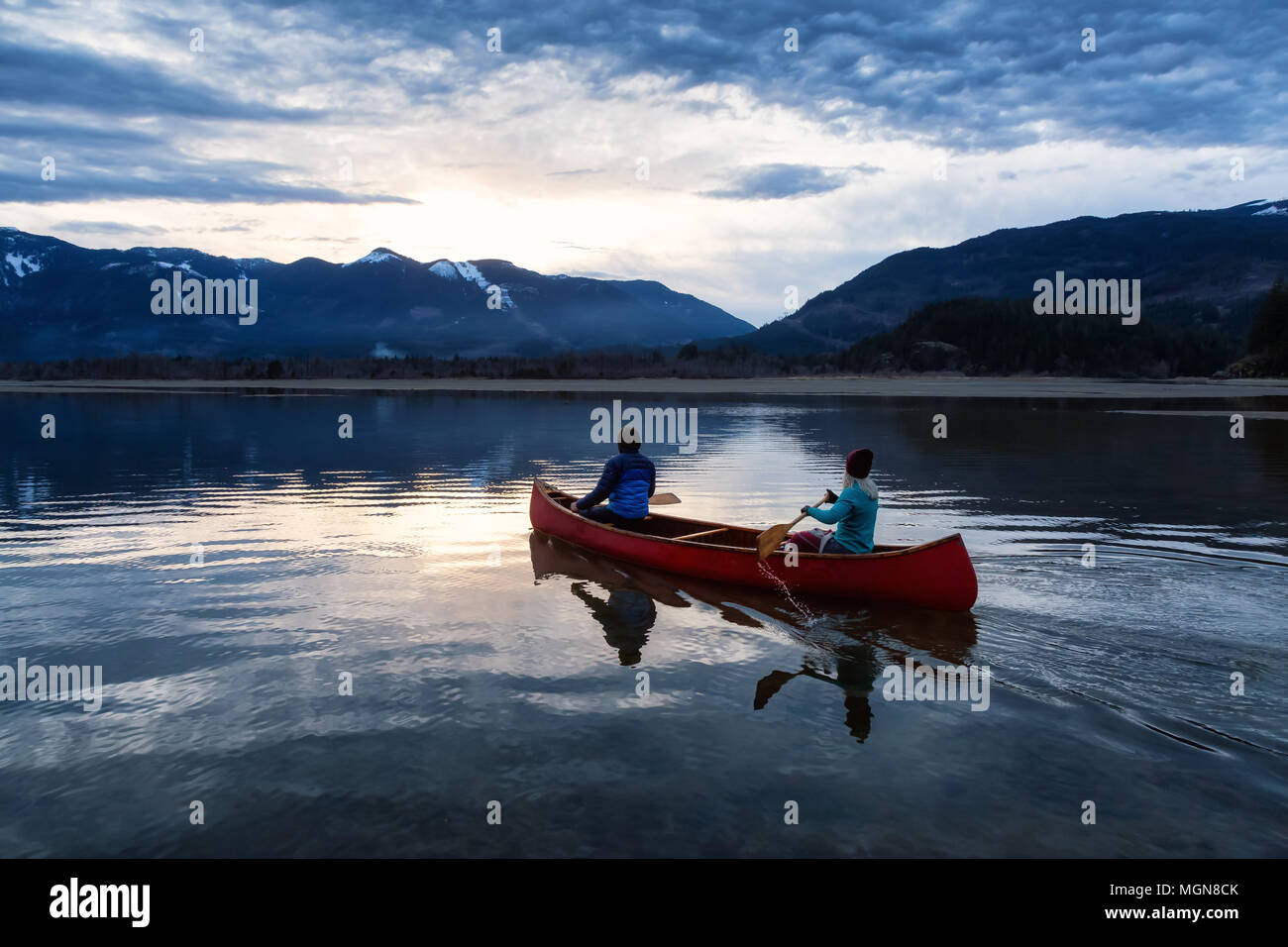 Adventurous people on a wooden canoe are enjoying the beautiful ...