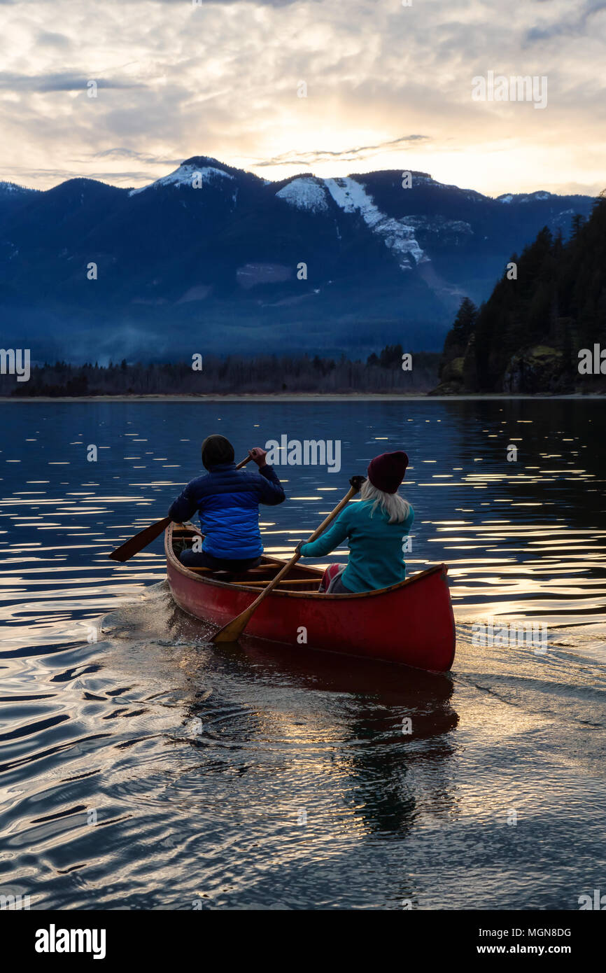 Adventurous people on a wooden canoe are enjoying the beautiful ...