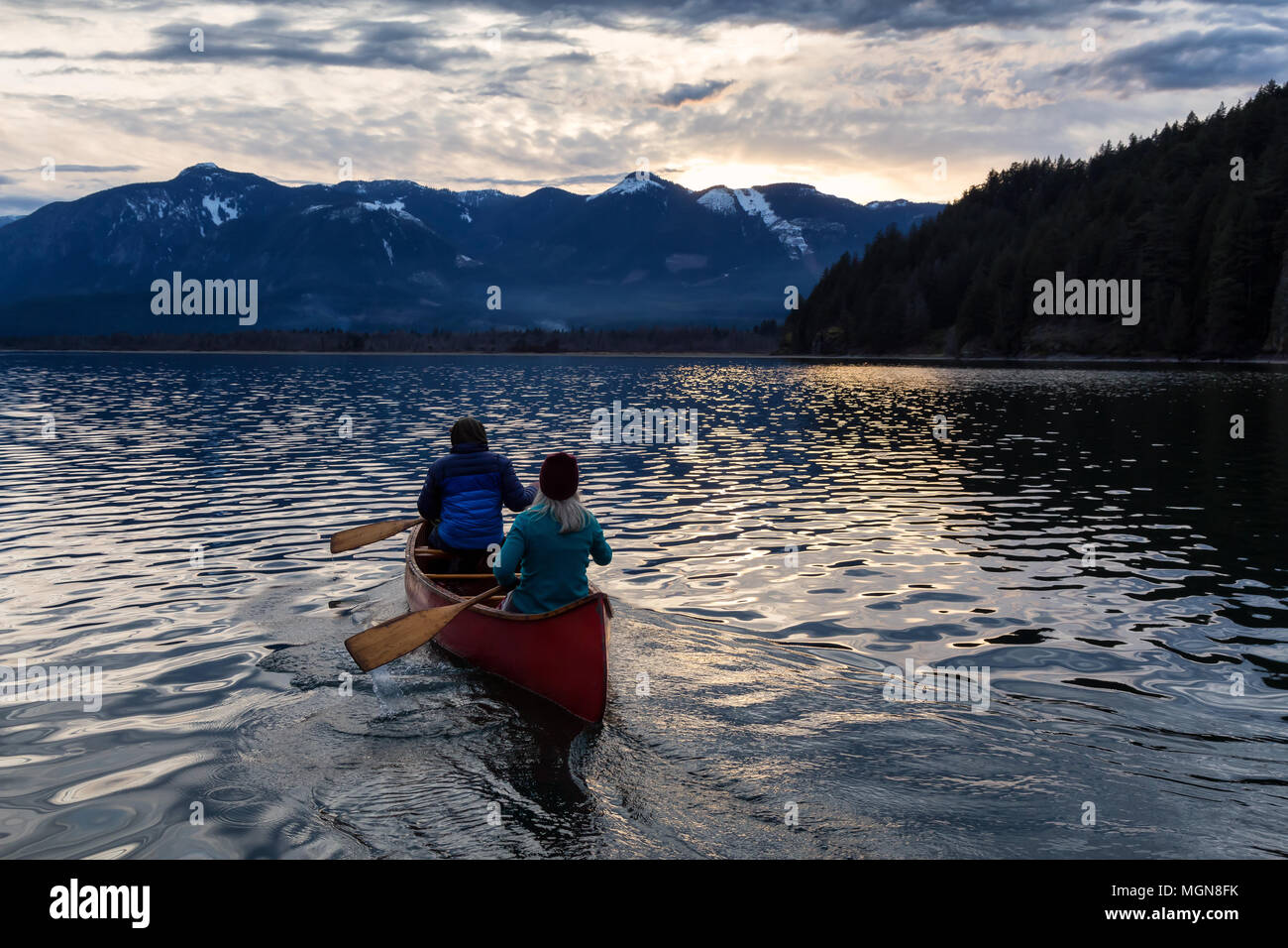 Adventurous people on a wooden canoe are enjoying the beautiful ...