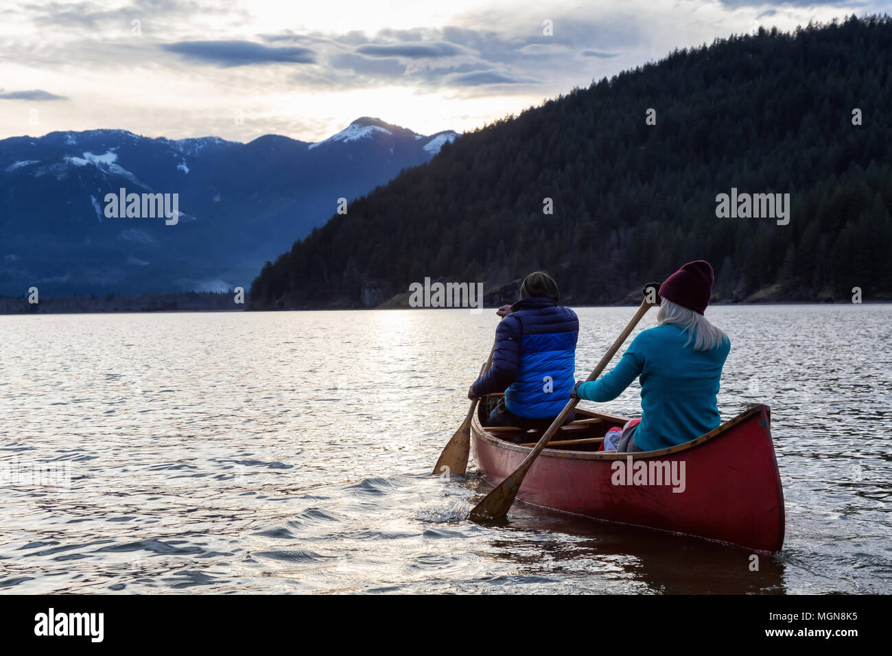 Adventurous people on a wooden canoe are enjoying the beautiful ...