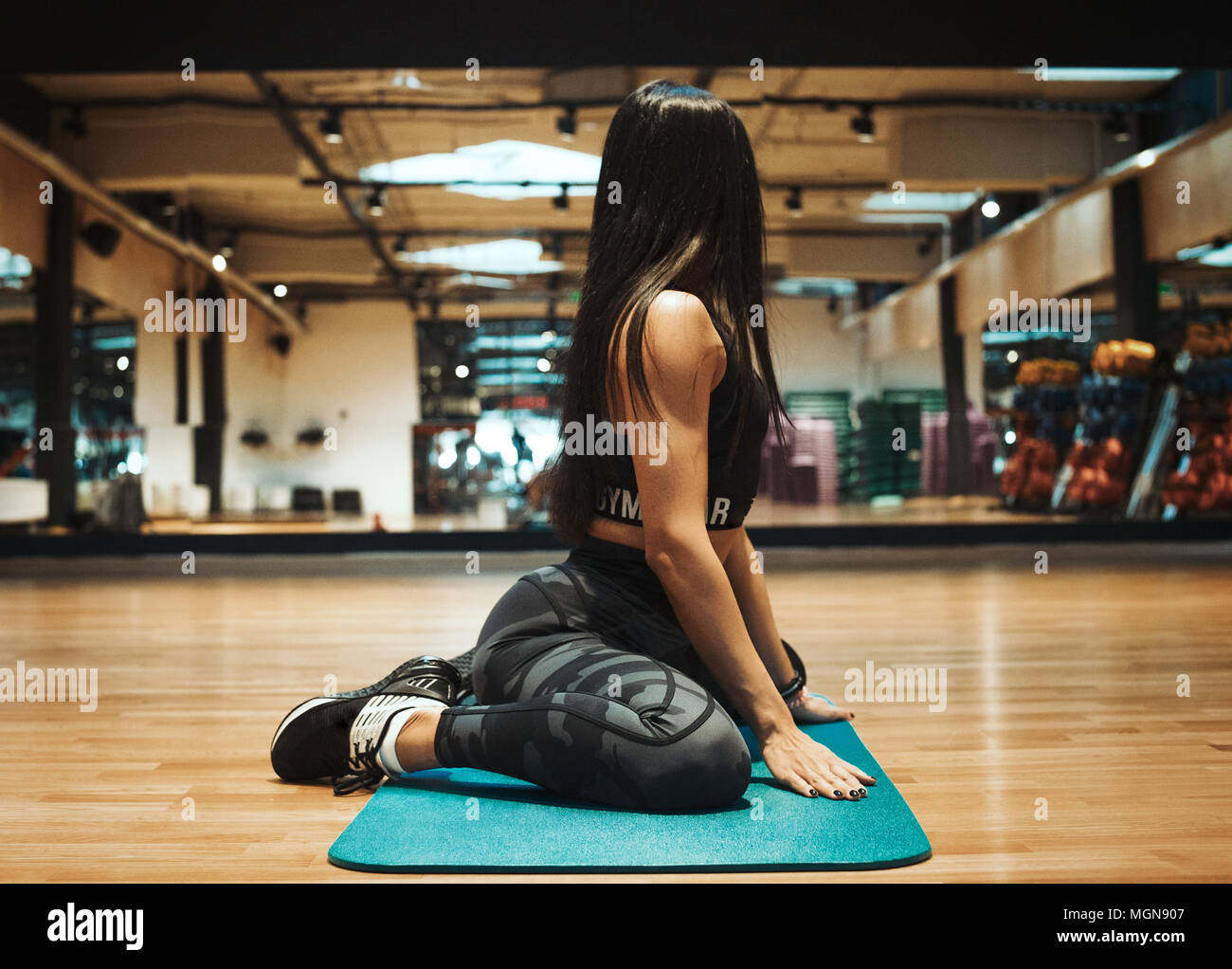 Young brunette girl stretching in gym Stock Photo - Alamy