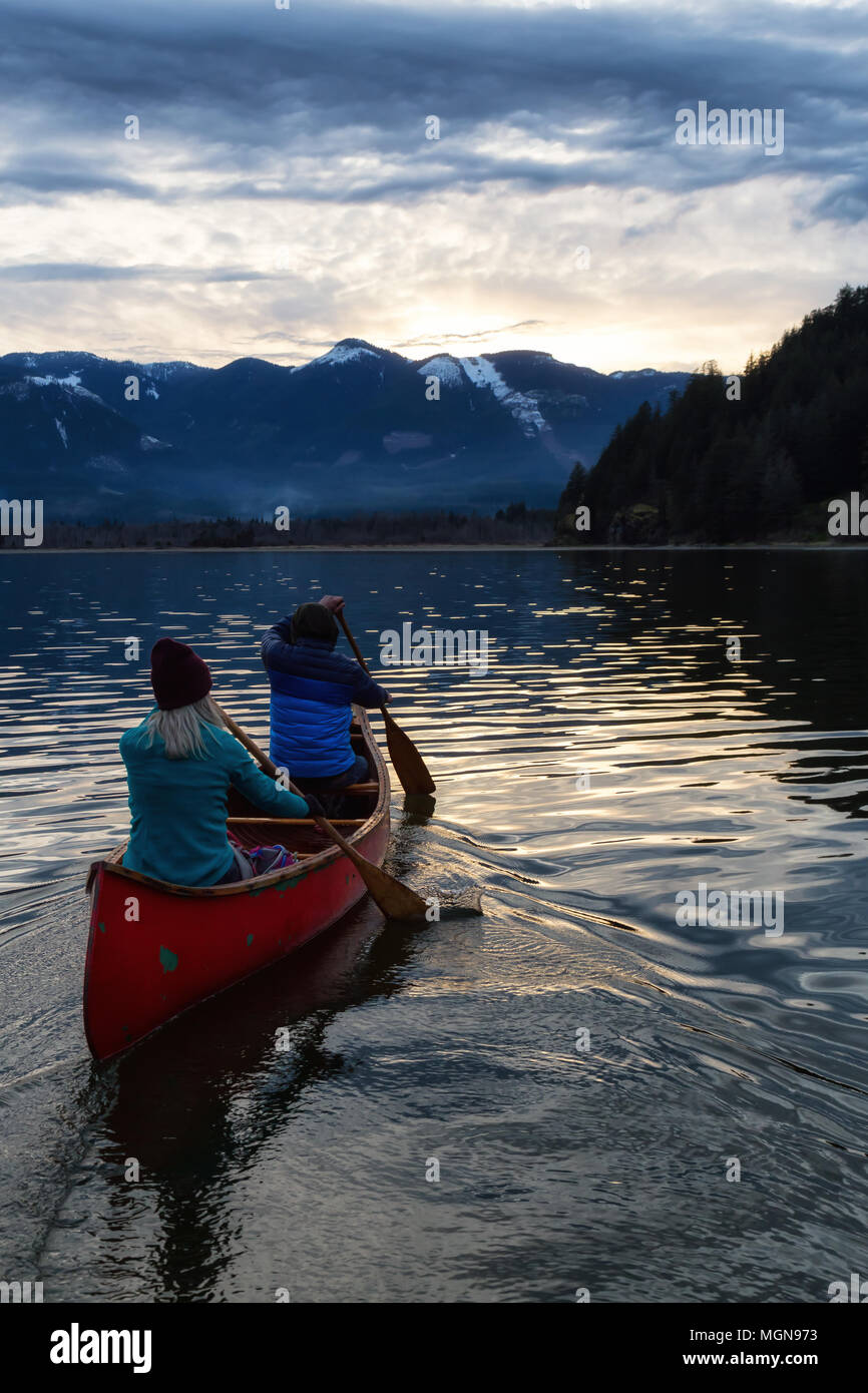 Adventurous people on a wooden canoe are enjoying the beautiful ...