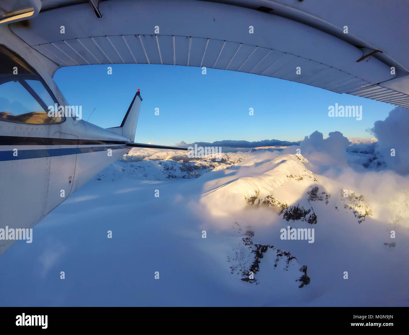 Small airplane flying over the Canadian Mountain Landscape during a ...