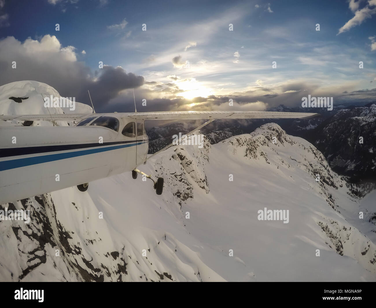 Small airplane flying over the Canadian Mountain Landscape during a ...