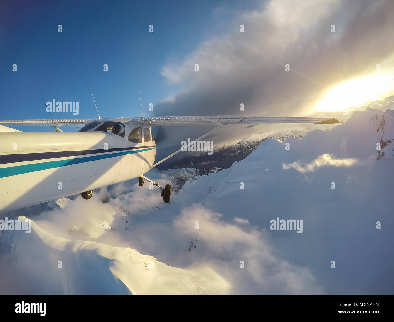 Small airplane flying over the Canadian Mountain Landscape during a ...