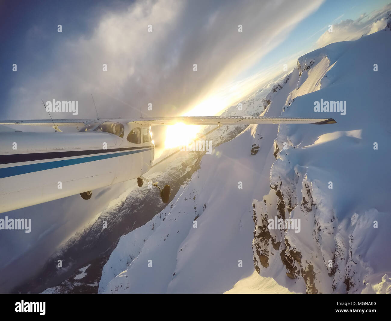 Small airplane flying over the Canadian Mountain Landscape during a ...