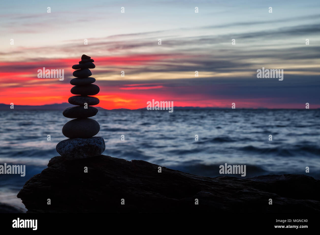 Stack of Rocks piled up by the ocean during a colorful sunset. Taken in ...