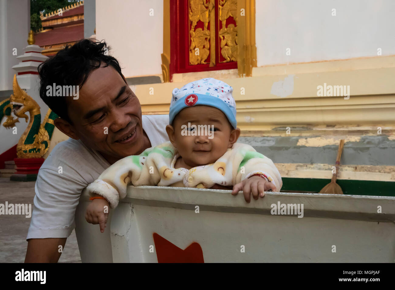 Man with young child at Pha That Luang, Vientiane, Laos Stock Photo - Alamy