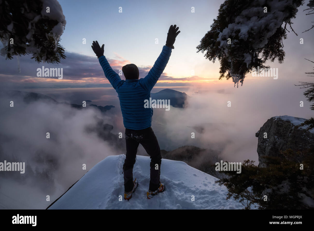 Adventurous man standing on the side of a steep cliff during a ...
