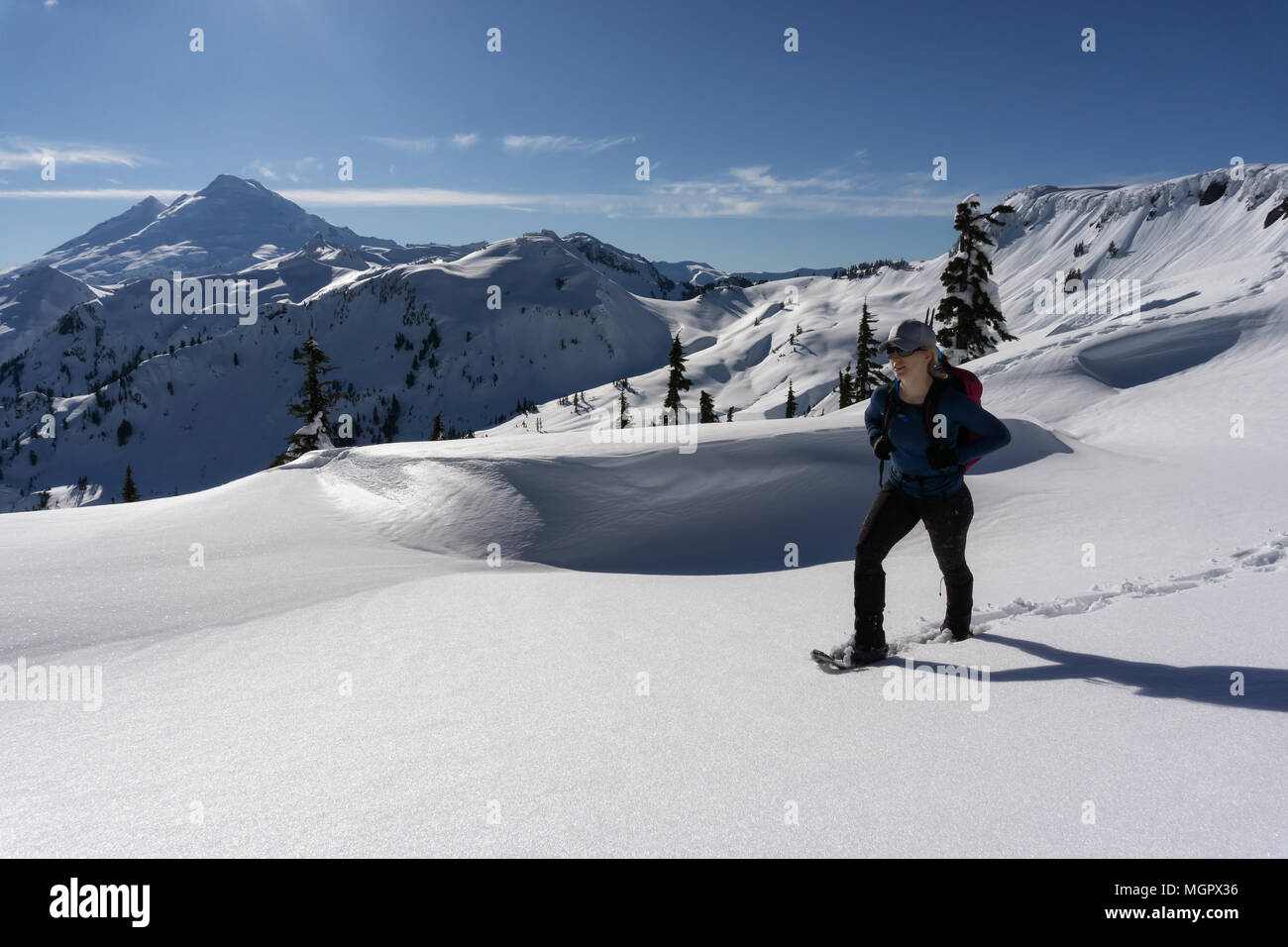 Adventurous woman is snowshoeing in the beautiful mountainous landscape ...