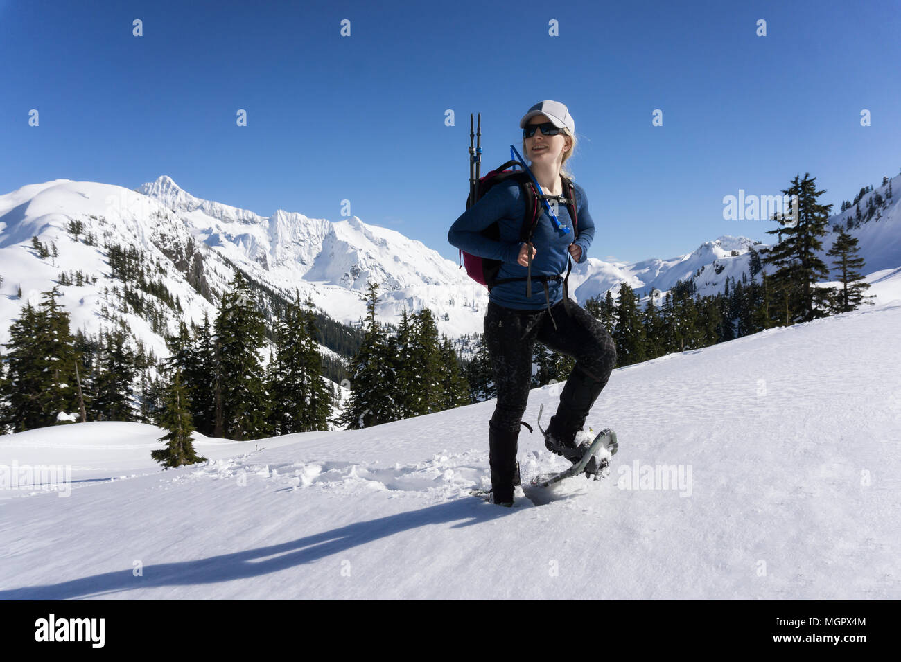 Adventurous woman is snowshoeing in the beautiful mountainous landscape ...