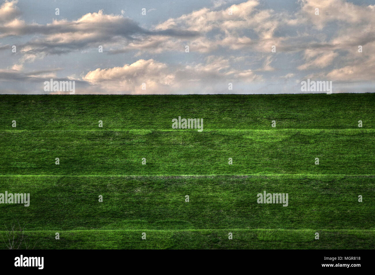 Grassy layered hill with beautiful cloudy sky Stock Photo - Alamy