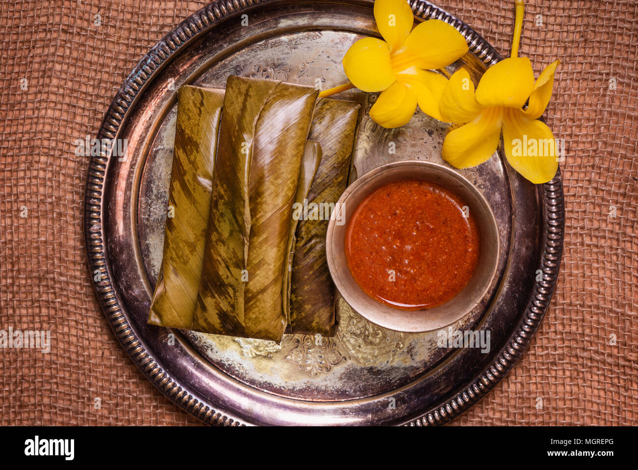 top view of sticky rice wrapped in leaves and served with peanut sauce ...