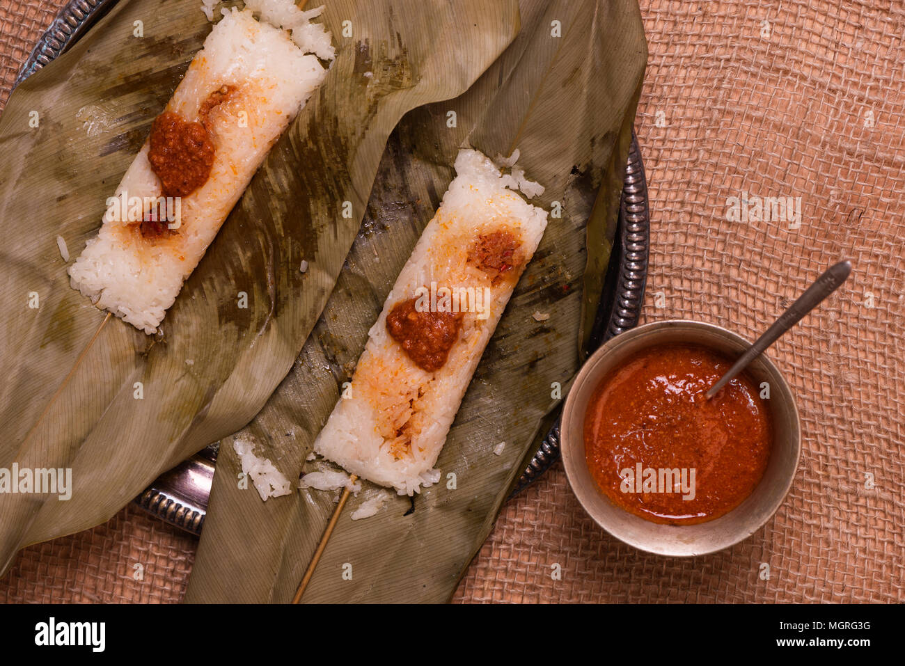 top view of open sticky rice wrapped in leaves and served with peanut ...