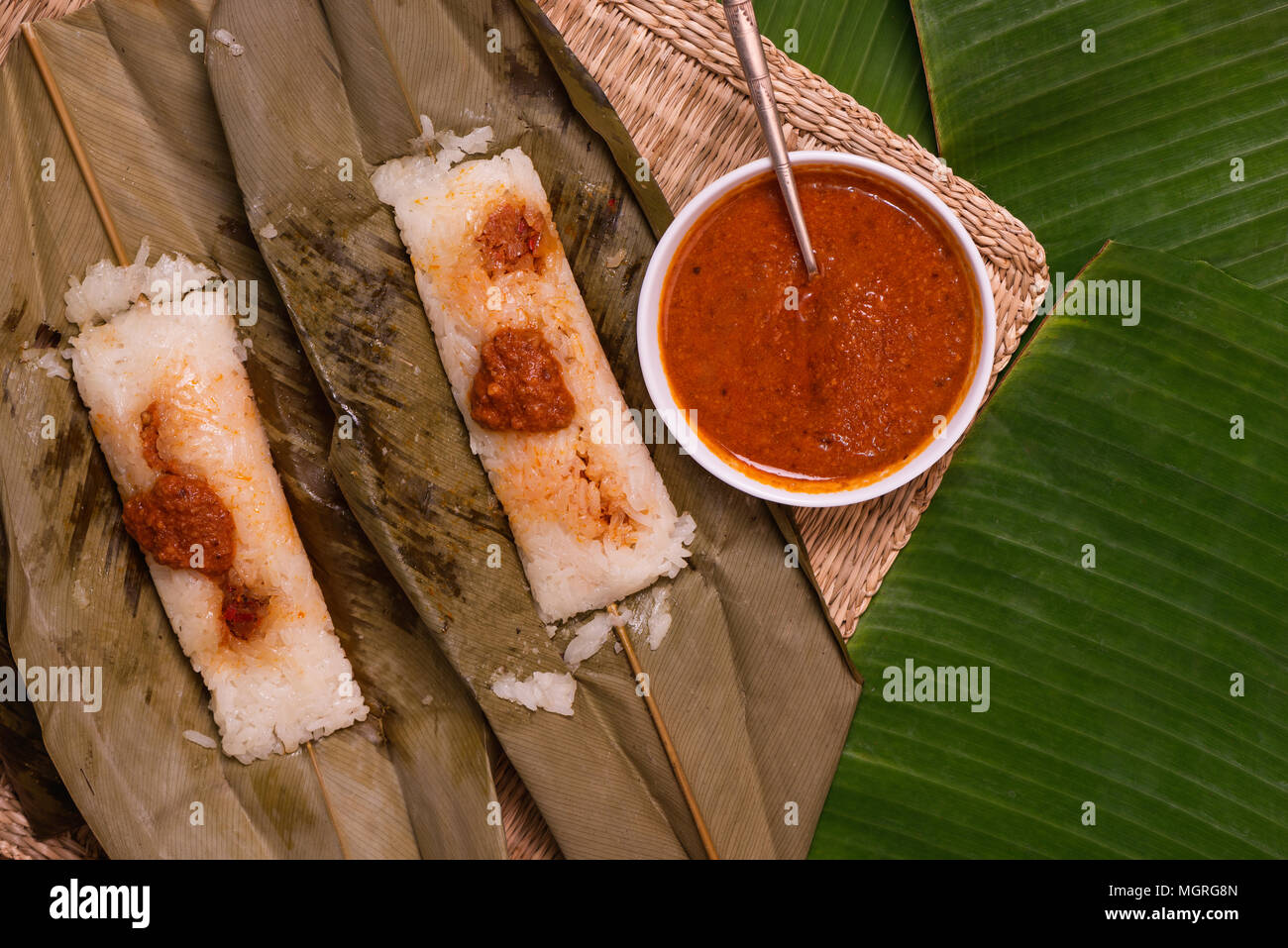 top view of open sticky rice wrapped in leaves and served with peanut ...